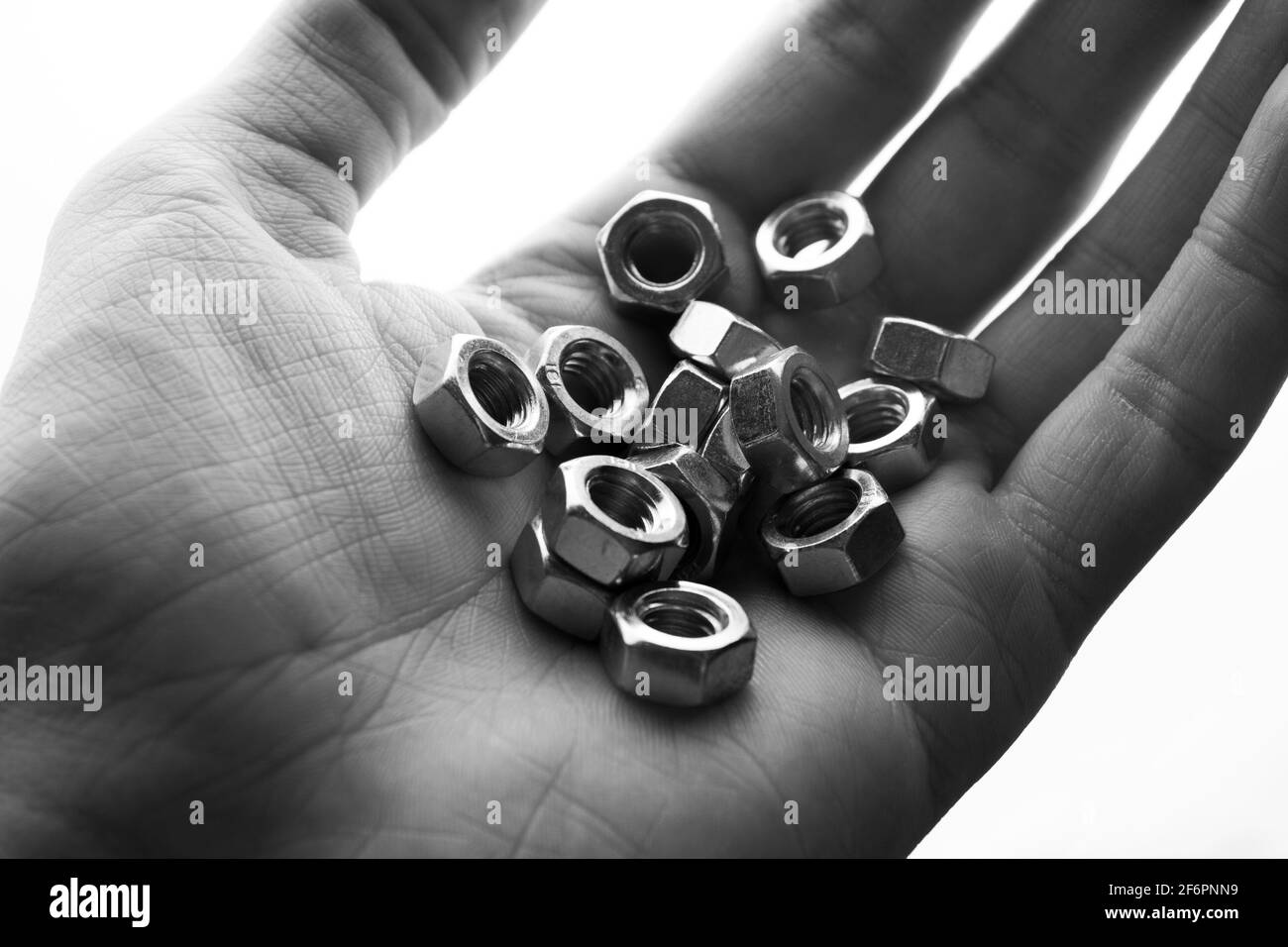 screw-nuts in hands on a white background Stock Photo - Alamy