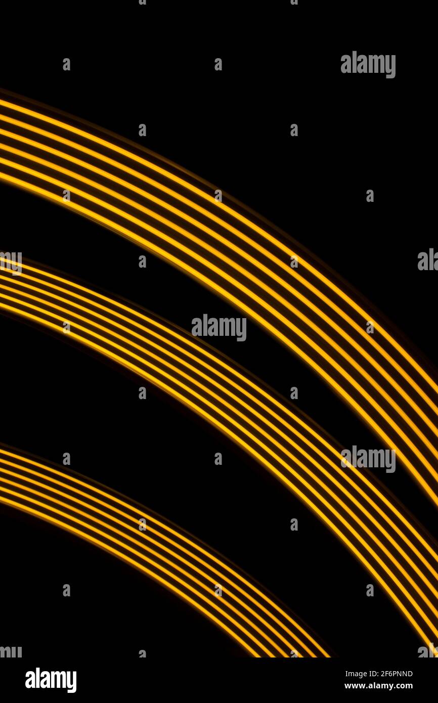 Yellow light lines on a black background Stock Photo - Alamy