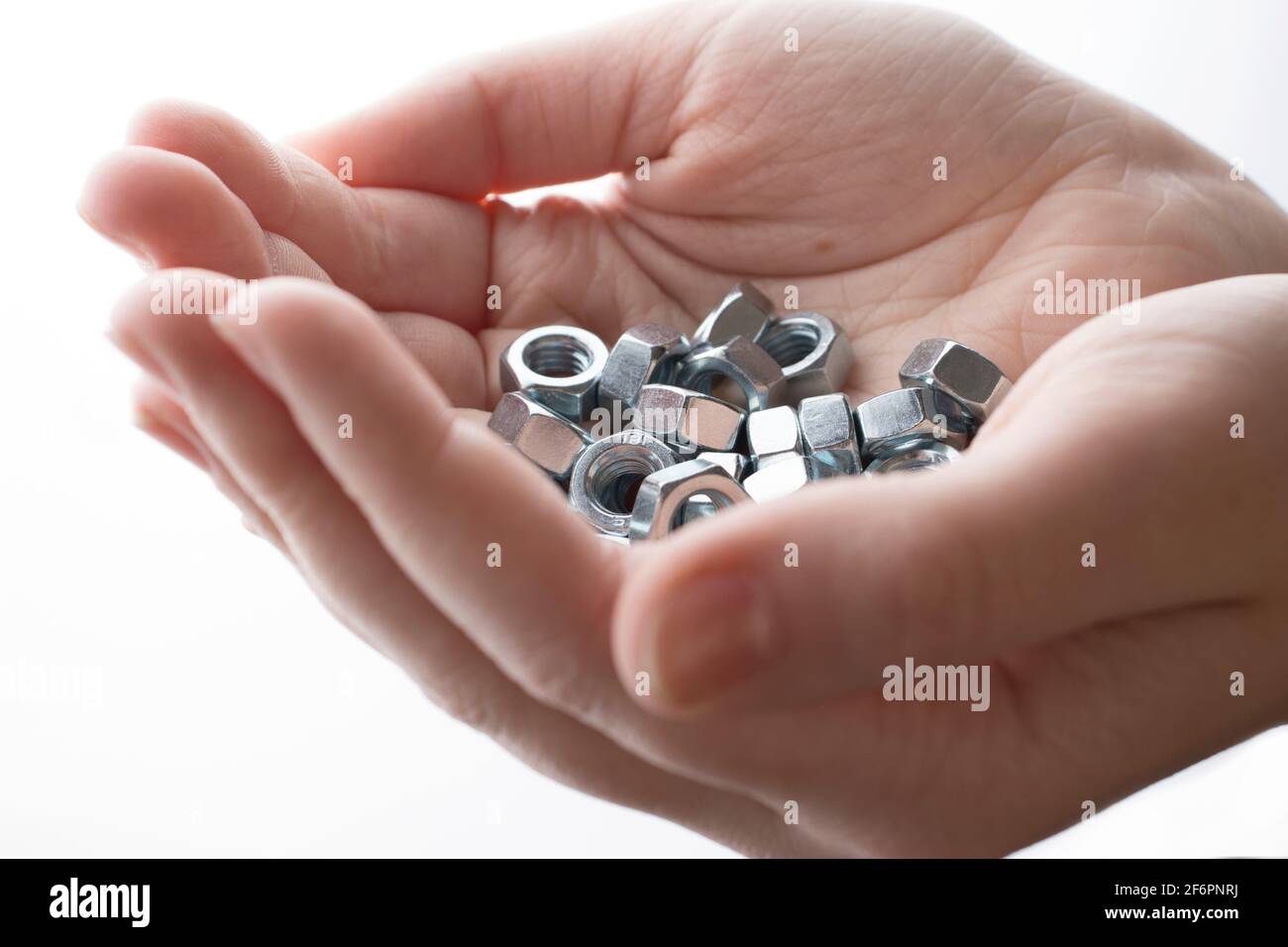 screw-nuts in hands on a white background Stock Photo - Alamy