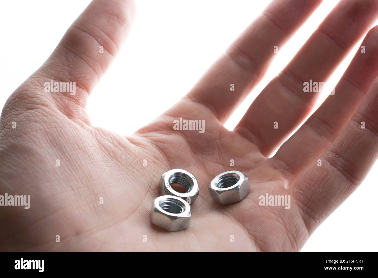 screw-nuts in hands on a white background Stock Photo - Alamy