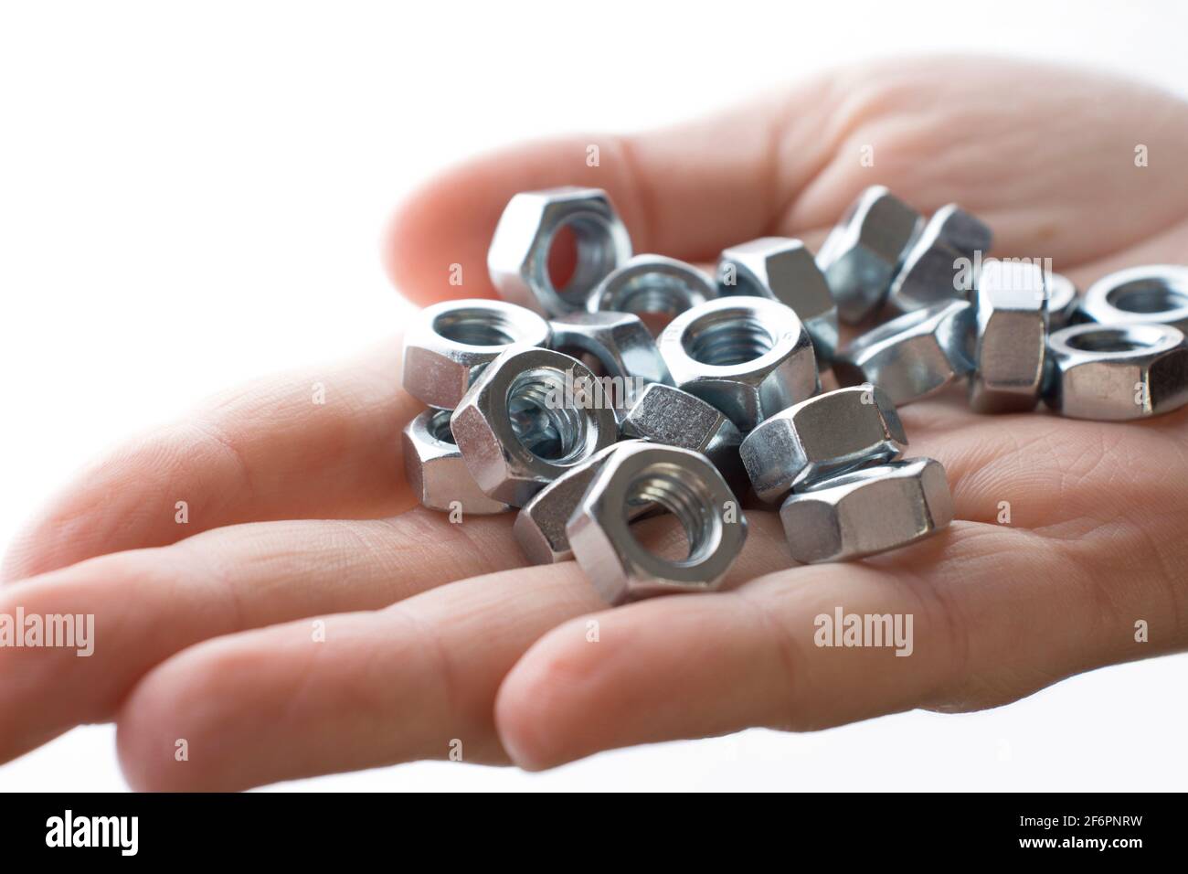 screw-nuts in hands on a white background Stock Photo - Alamy