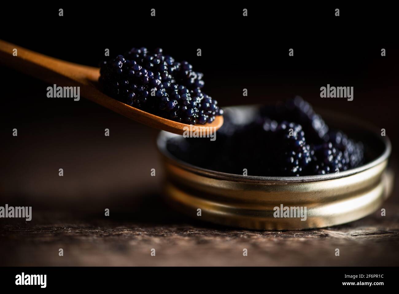 Black lumpfish caviar in a small pot and spoon close up Stock Photo - Alamy