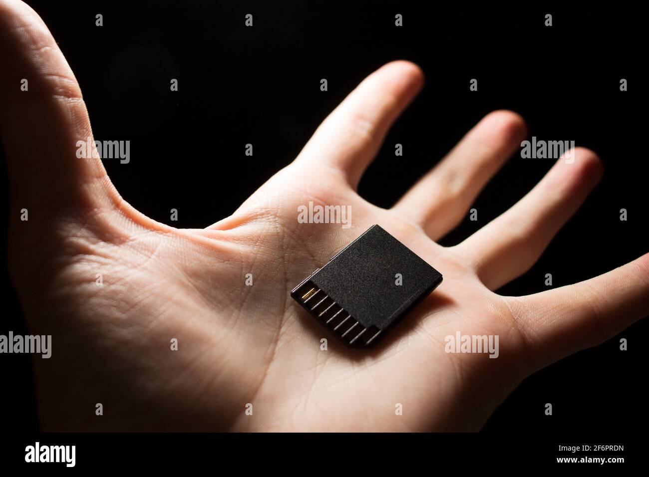 SD card in hand on a dark background Stock Photo - Alamy