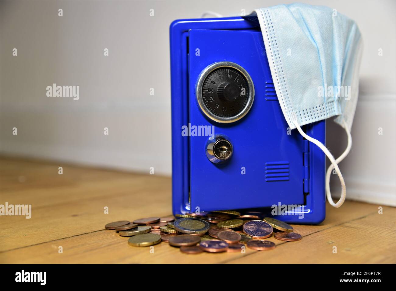 euro coins with a mask and a safe on a wood floor Stock Photo - Alamy