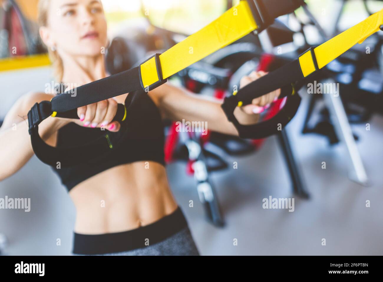 Women training with fitness straps in the gym. Beautiful lady ...