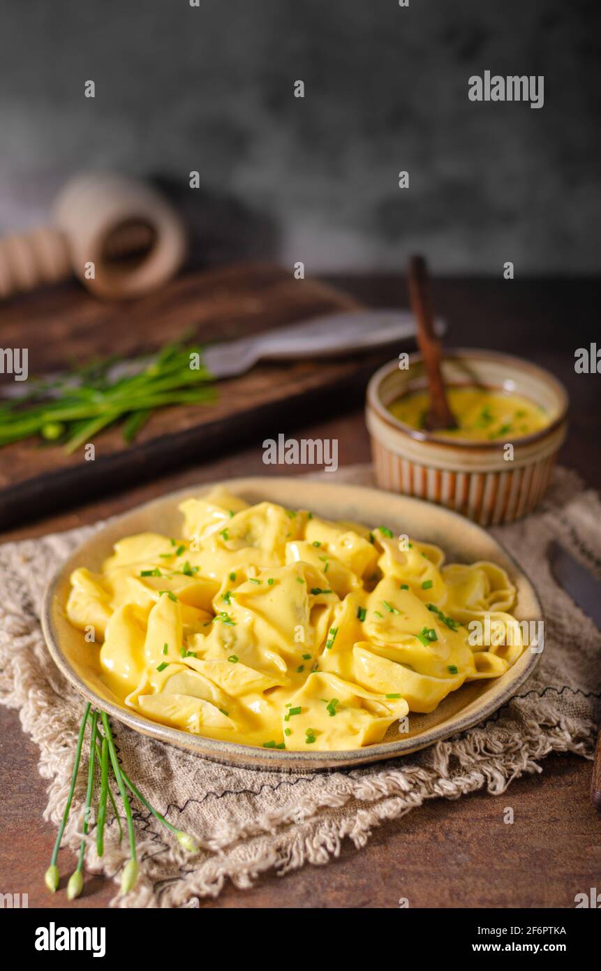 Homemade tortellini with delicious cheddar sauce and herbs Stock Photo - Alamy
