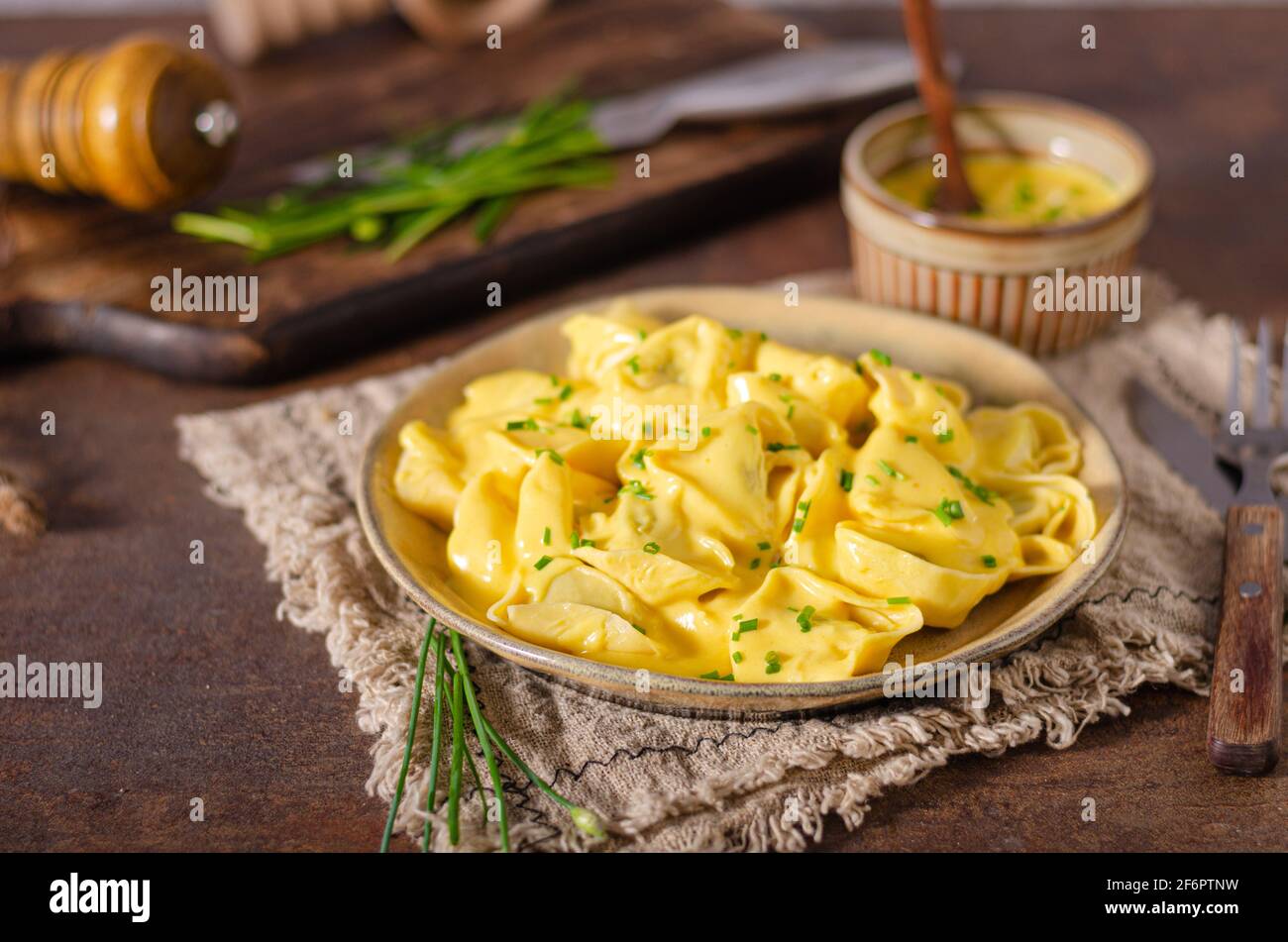 Homemade tortellini with delicious cheddar sauce and herbs Stock Photo - Alamy