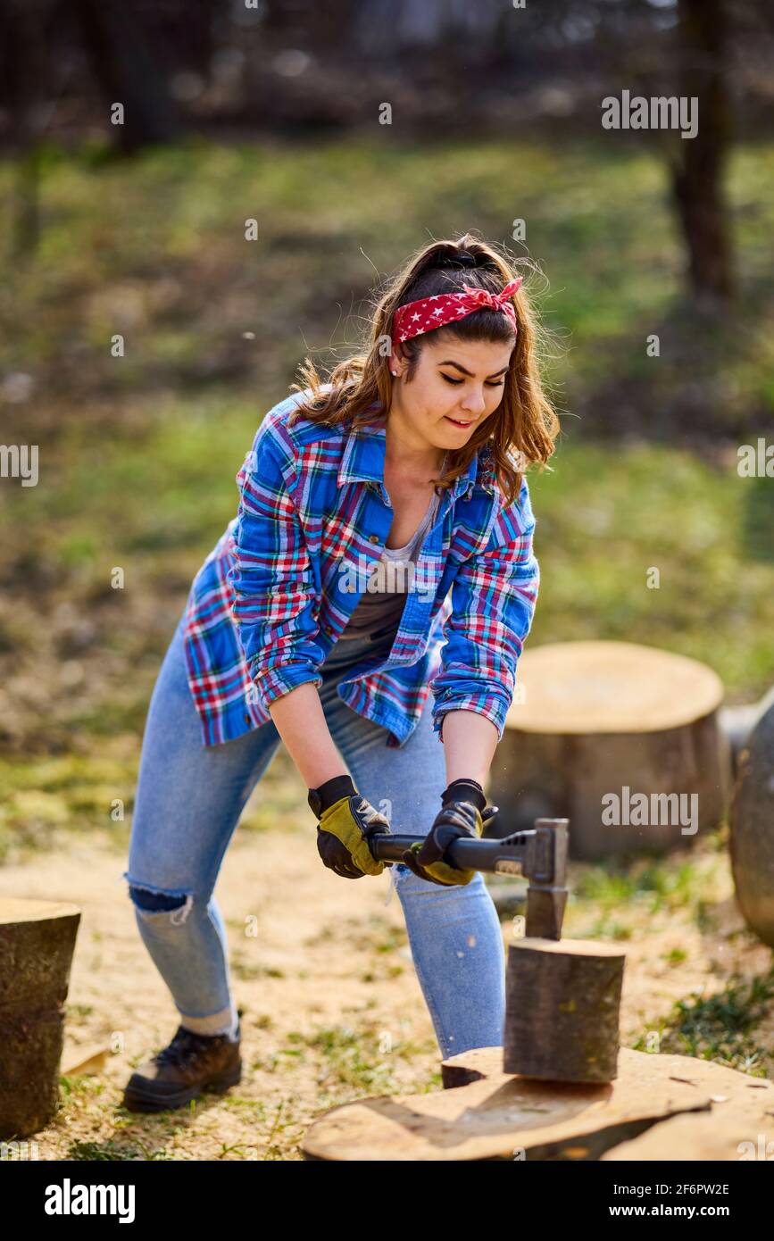 Female lumber breaks beech logs with a large ax Stock Photo - Alamy
