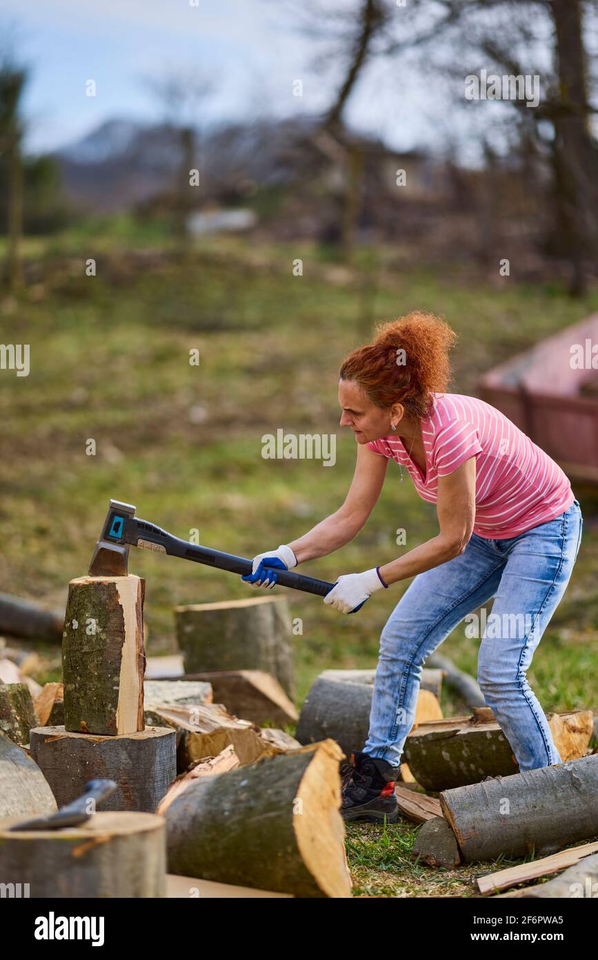 Woman splitting firewood hi-res stock photography and images - Alamy