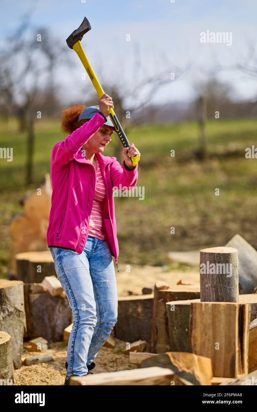 Strong woman splitting beech logs for firewood Stock Photo - Alamy