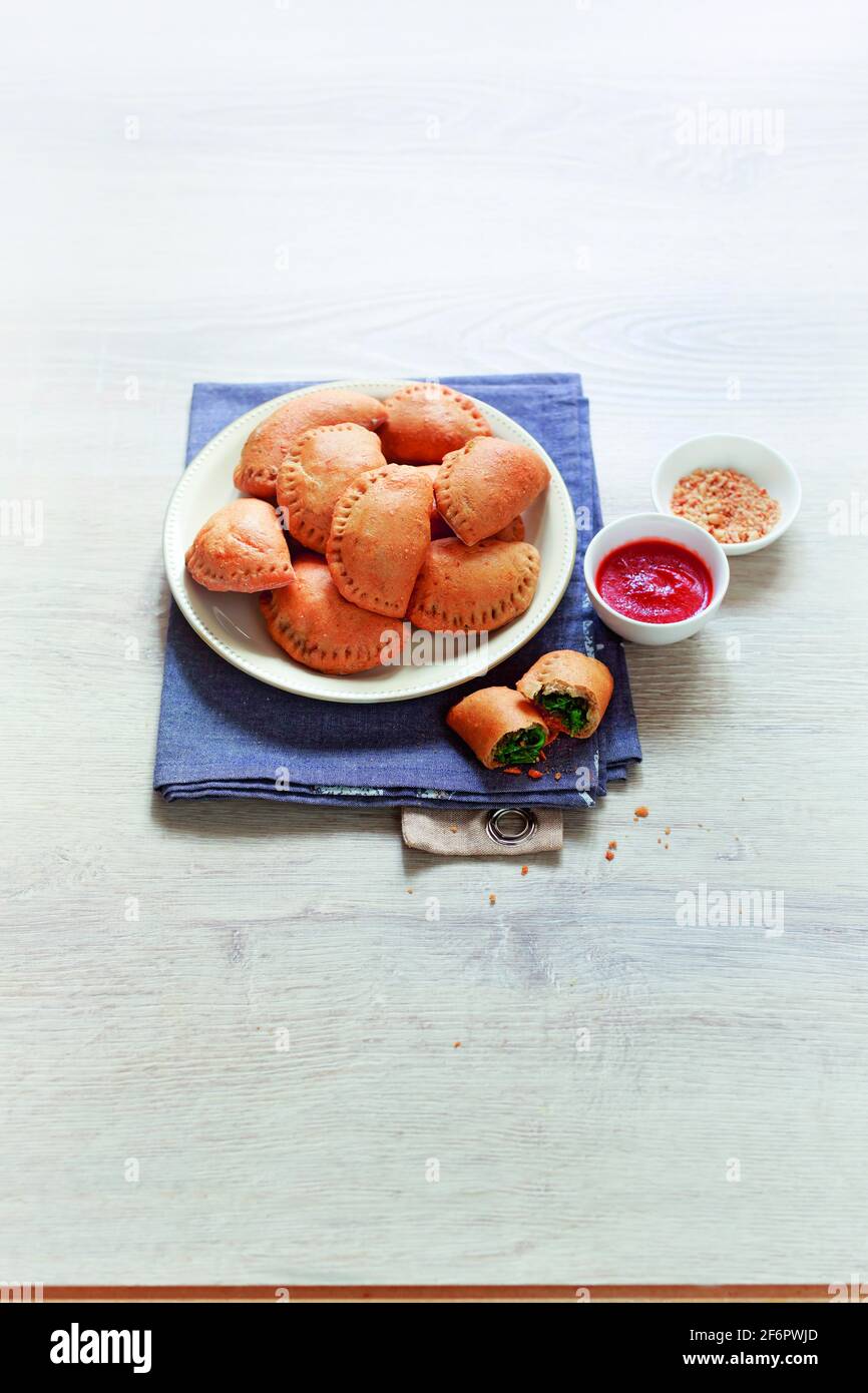 Italian panzerotti with spinach hazelnuts and tomato sauce Stock Photo ...