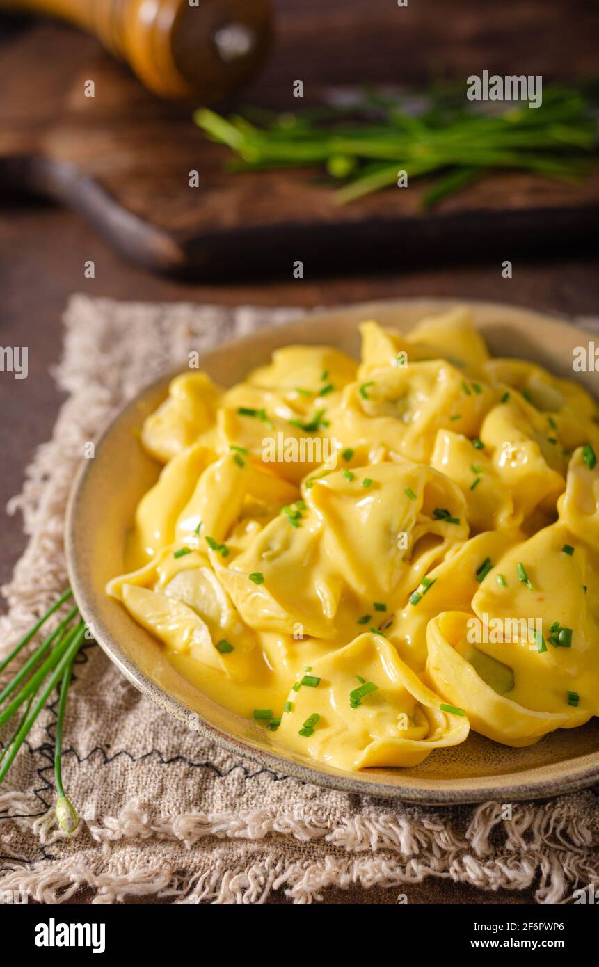 Homemade tortellini with delicious cheddar sauce and herbs Stock Photo - Alamy