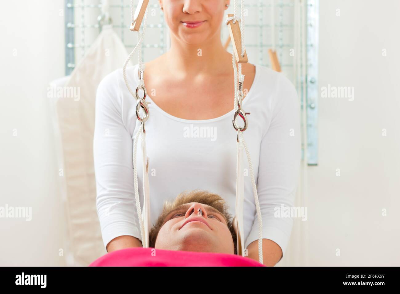 Patient at the physiotherapy doing physical exercises with loop table ...