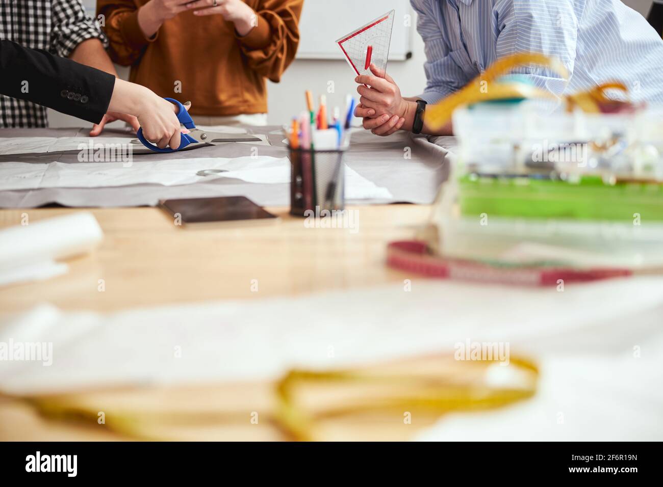 Scissors splitting open a piece of grey fabric Stock Photo - Alamy