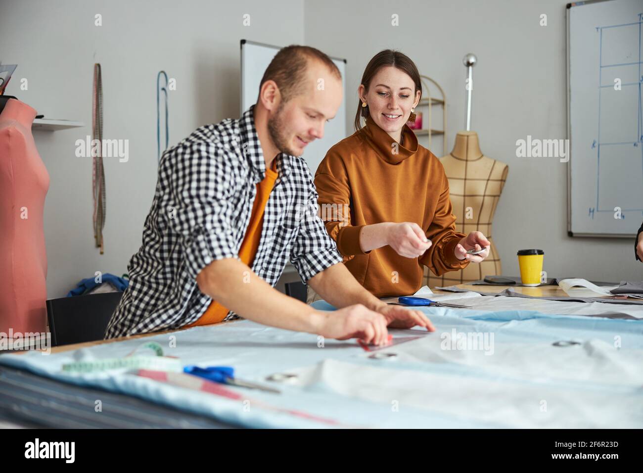 Man performing measurements on fabric with ruler Stock Photo - Alamy