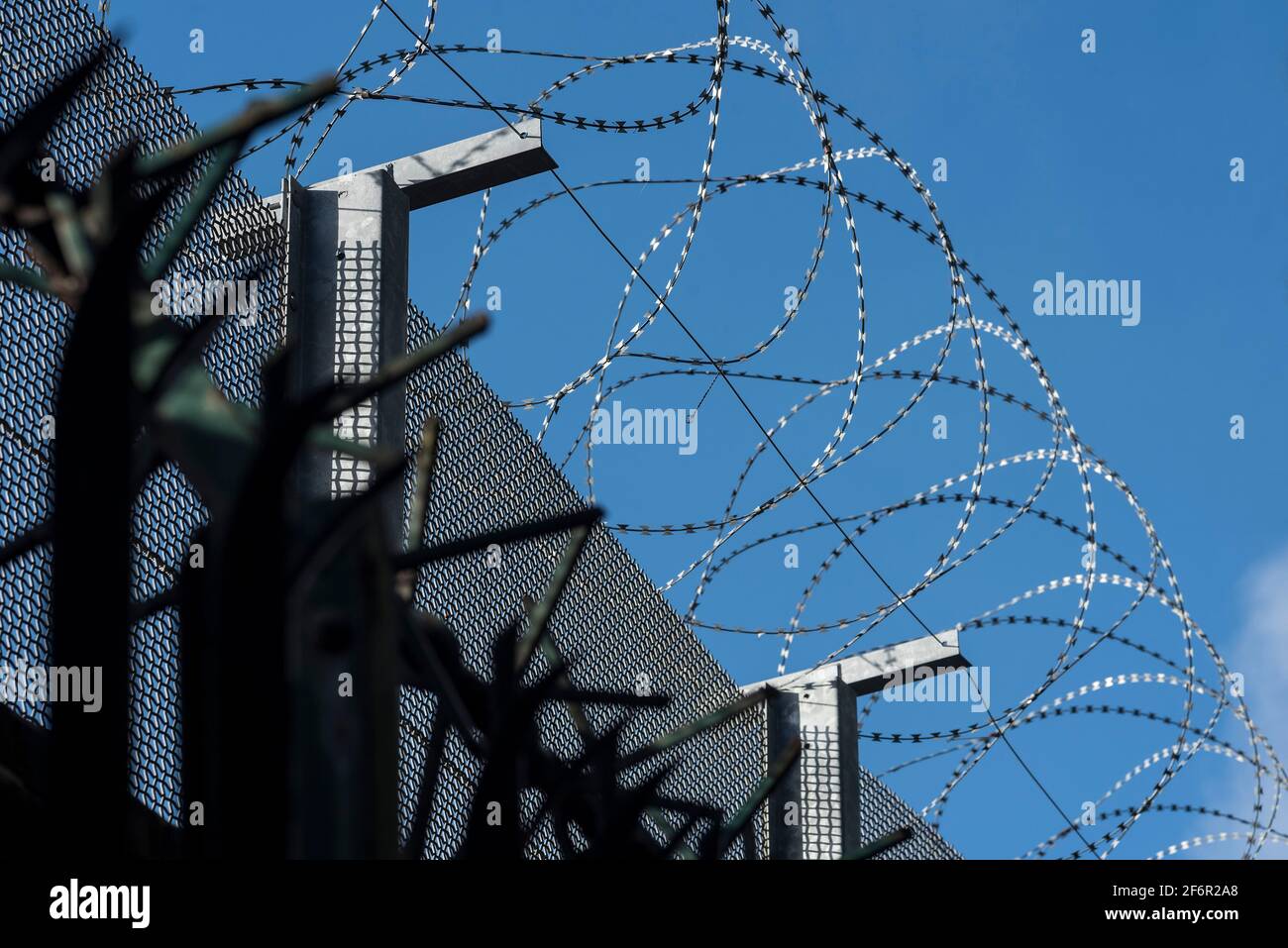Woven wire security fencing topped with razor wire and anti-climb ...
