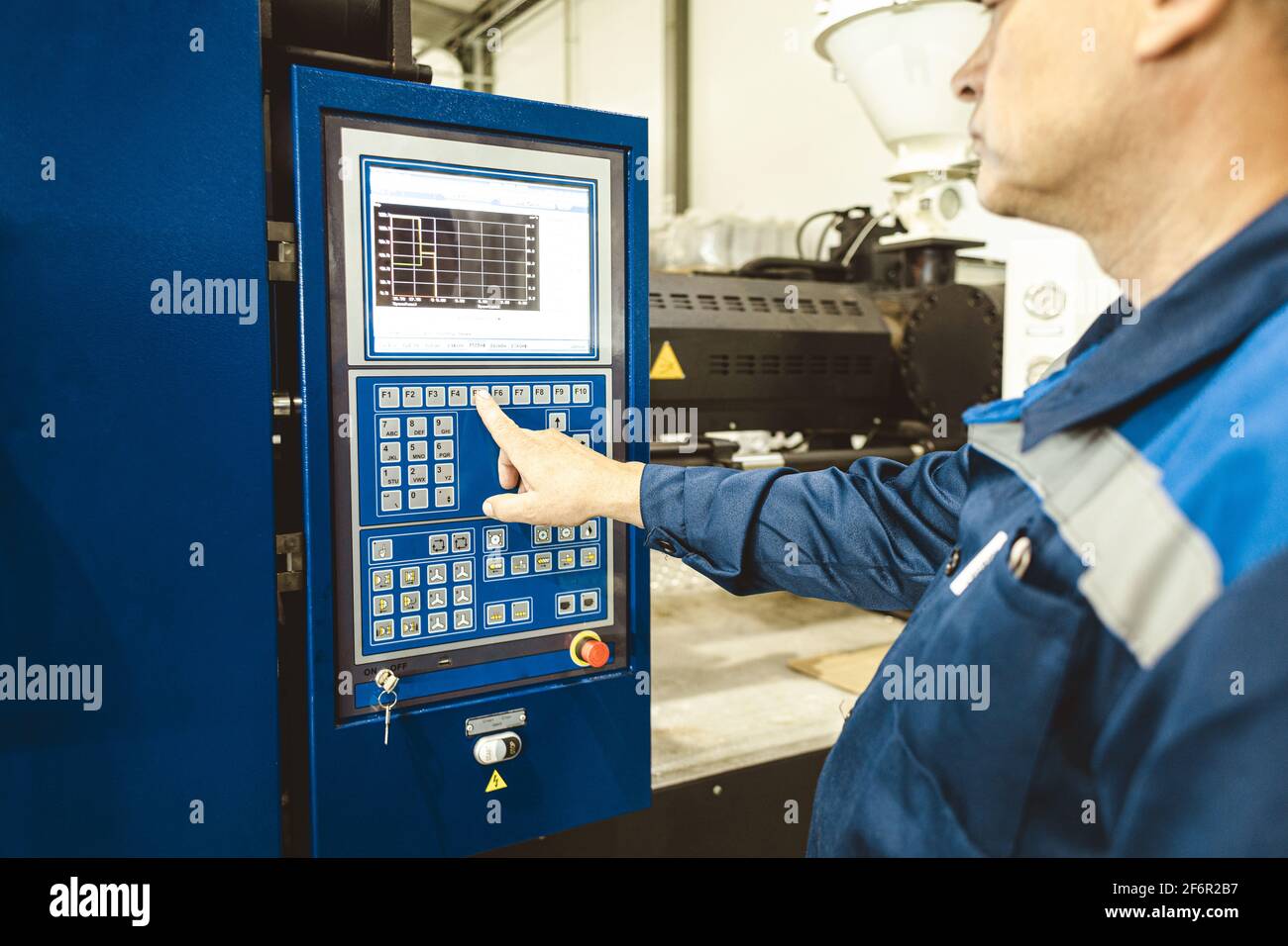 A worker presses a button and starts an automatic manufacturing process ...