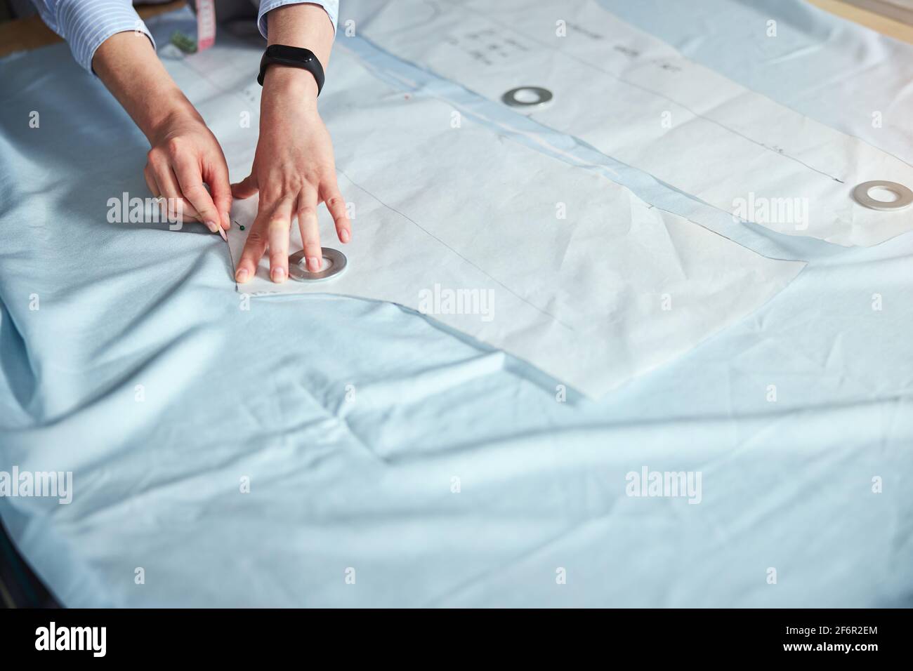 Person drawing with chalk around sewing pattern Stock Photo - Alamy