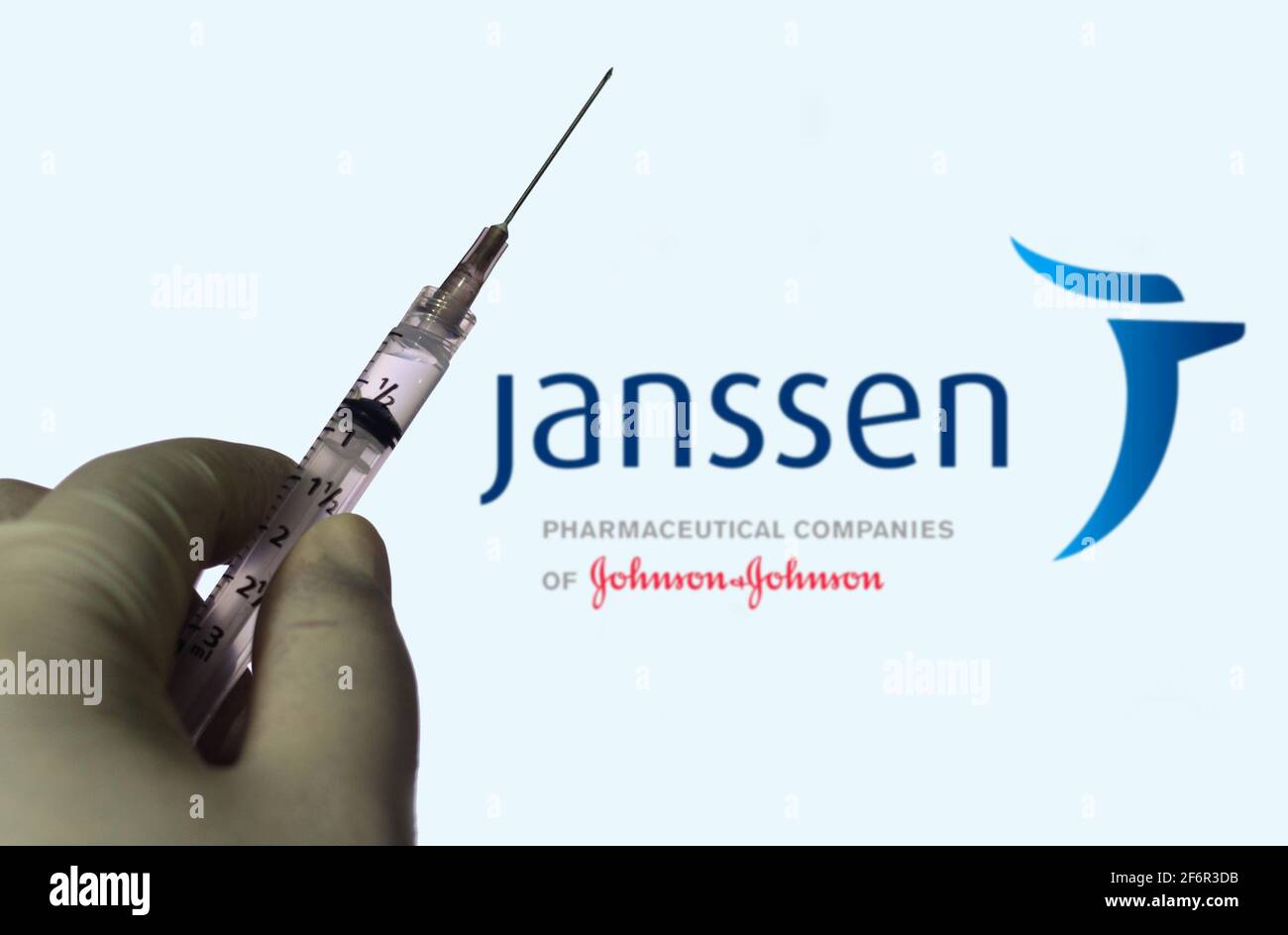 In this photo illustration, a hand holds a medical syringe with a ...
