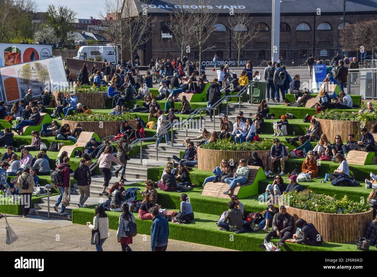People enjoy the sunshine on the steps at Granary Square in King's ...