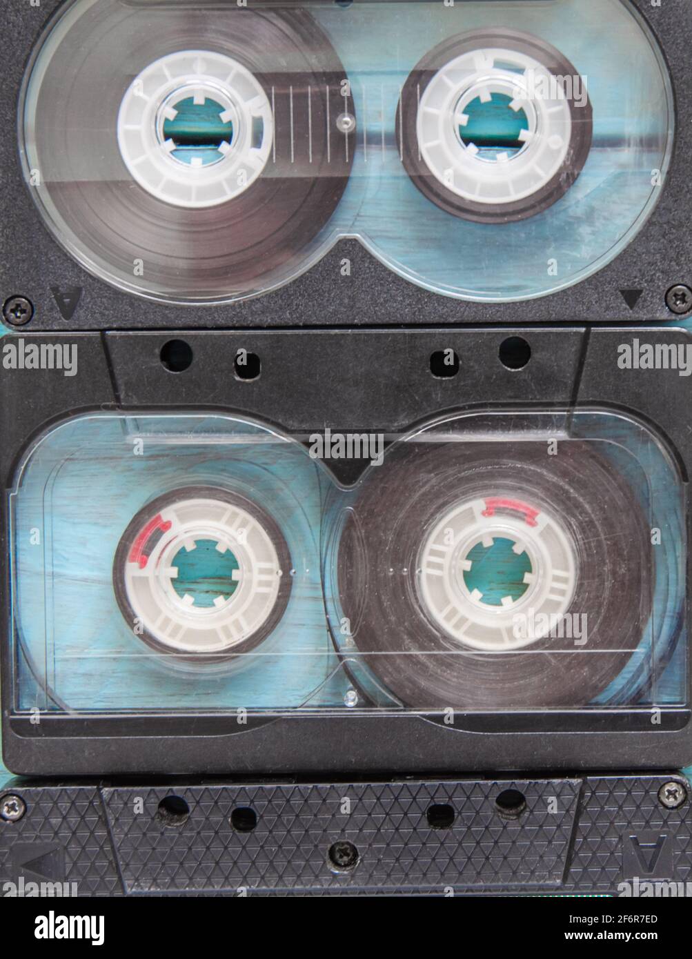 Two worn audio cassettes in a black and transparent case close-up. Top ...