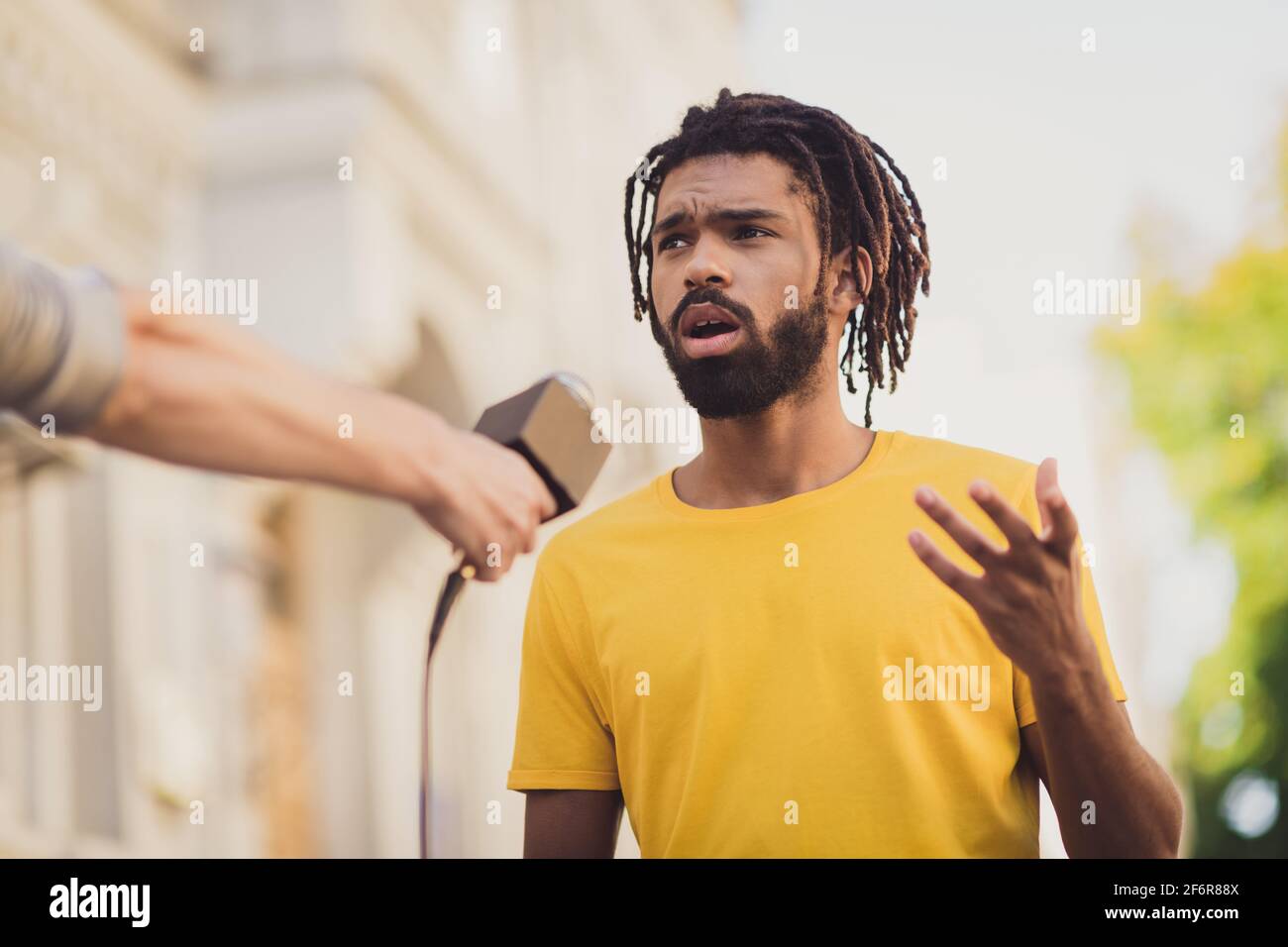 Photo portrait of young man giving interview on street speaking on ...