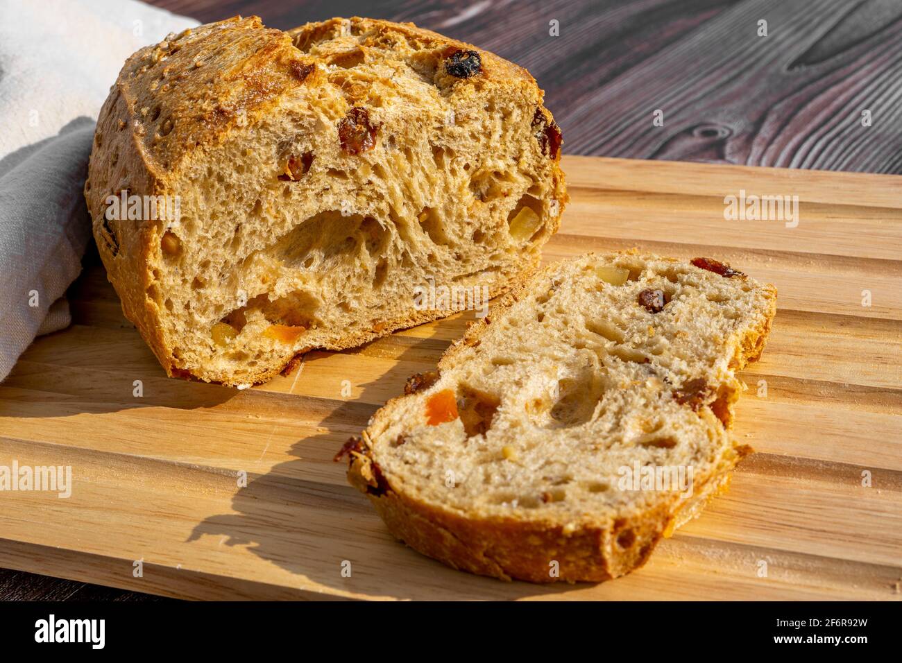 Homemade whole grain bread with dried fruits and nuts cut to slice on a ...