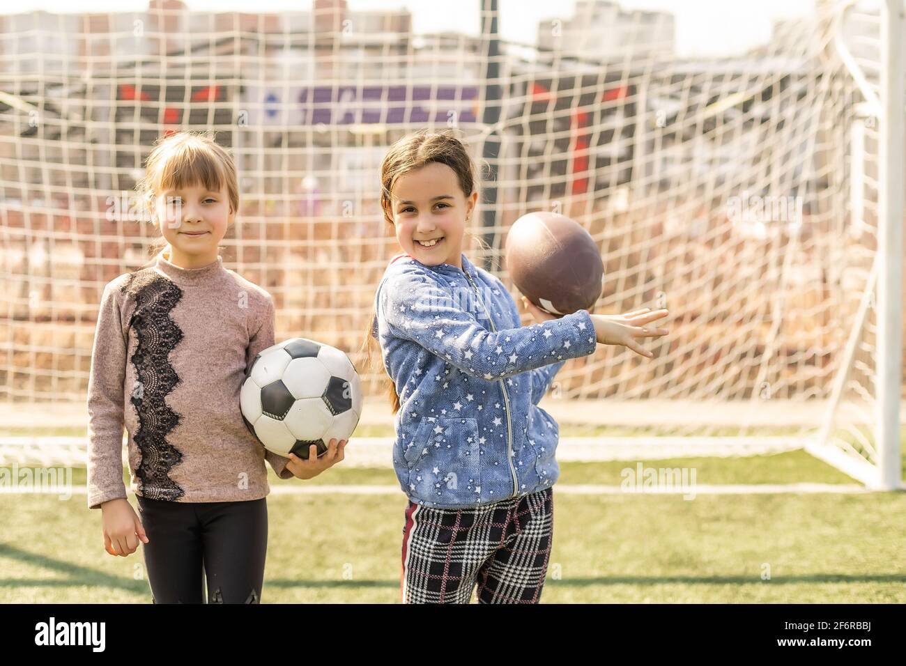 Little football team: toddler girls with soccer ball at football field ...