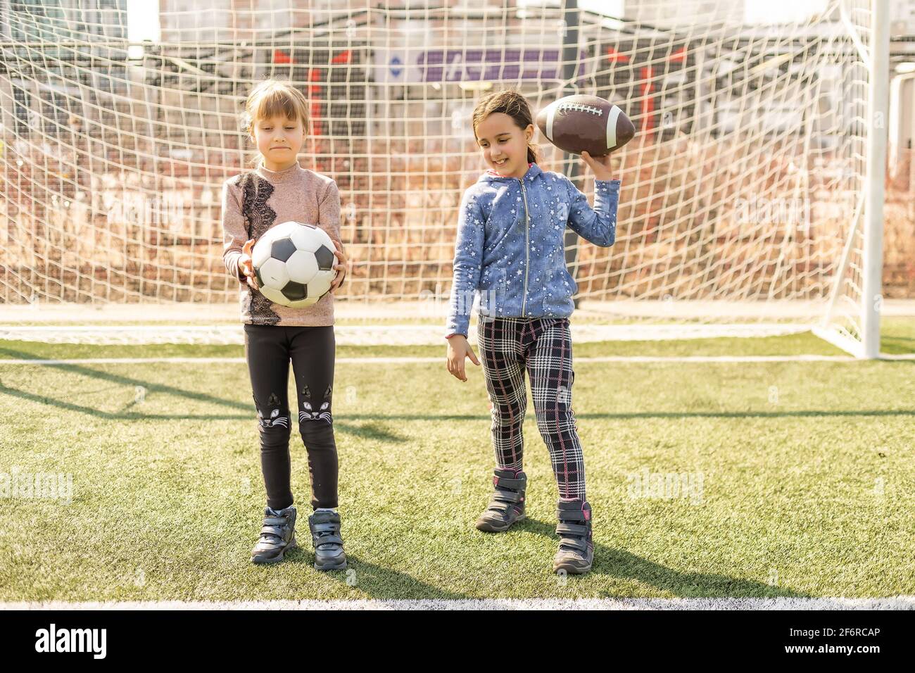 Kids play football on outdoor field. Children score a goal at soccer ...