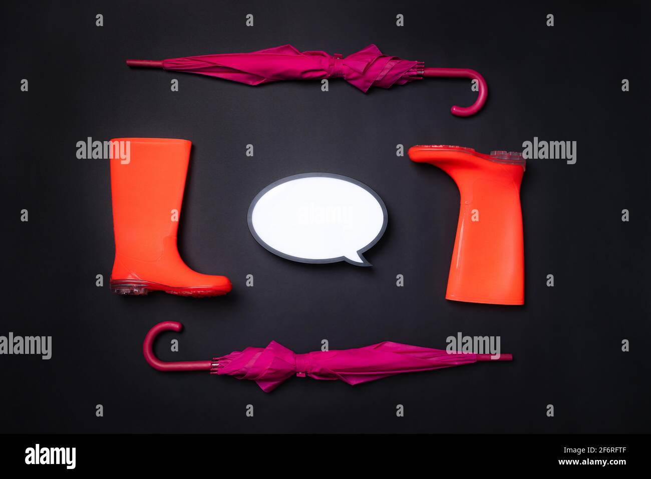 Rubber shoes, umbrella and speech bubble on black background. Rain ...