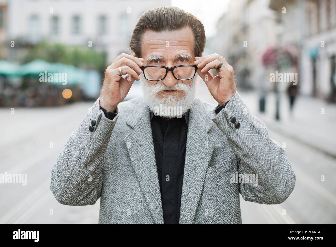 Bearded man adjusting eyeglasses hi-res stock photography and images ...