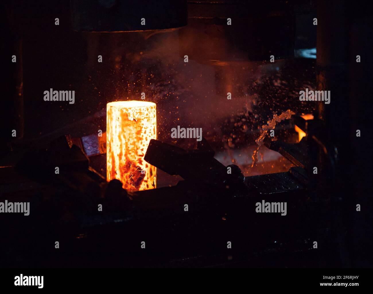 Production of bearing rings on mechanical press. Red-hot metal cylinder ...