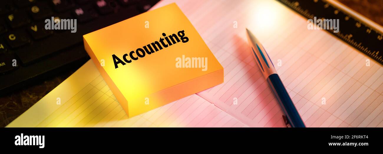 text ACCOUNTING. Note on orange sticker lying on notepad next to a ...