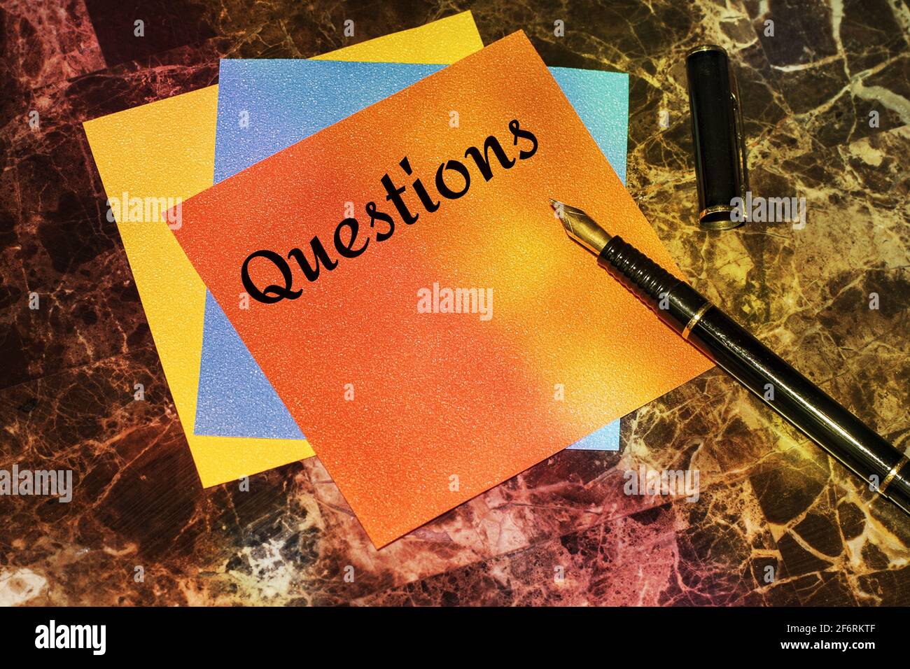 Word Writing Text QUESTIONS on a stack of multi-colored memo stickers ...