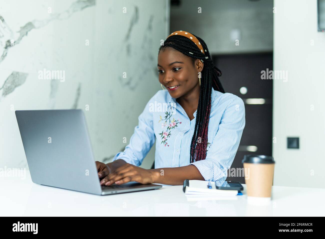 Smiling black woman using computer in modern kitchen interior Stock ...