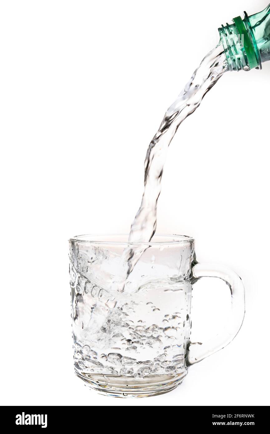 Water poured from a bottle into a glass. Quenching thirst with drinking ...