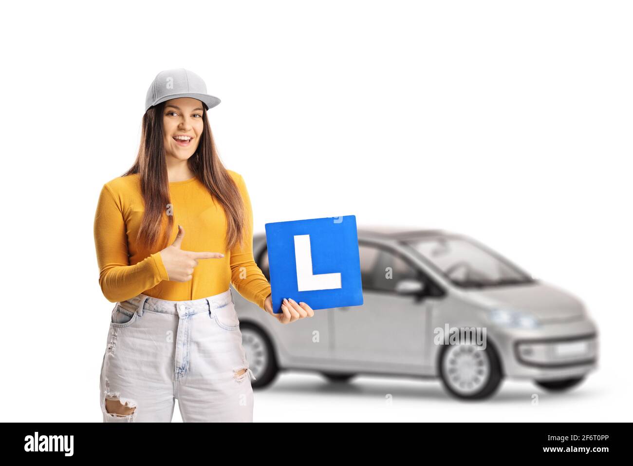 Young female driver with a learner plate and a small silver car ...