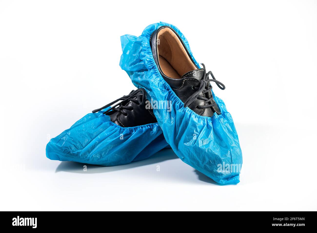 Blue plastic protective shoe covers on mens black leather shoes ...