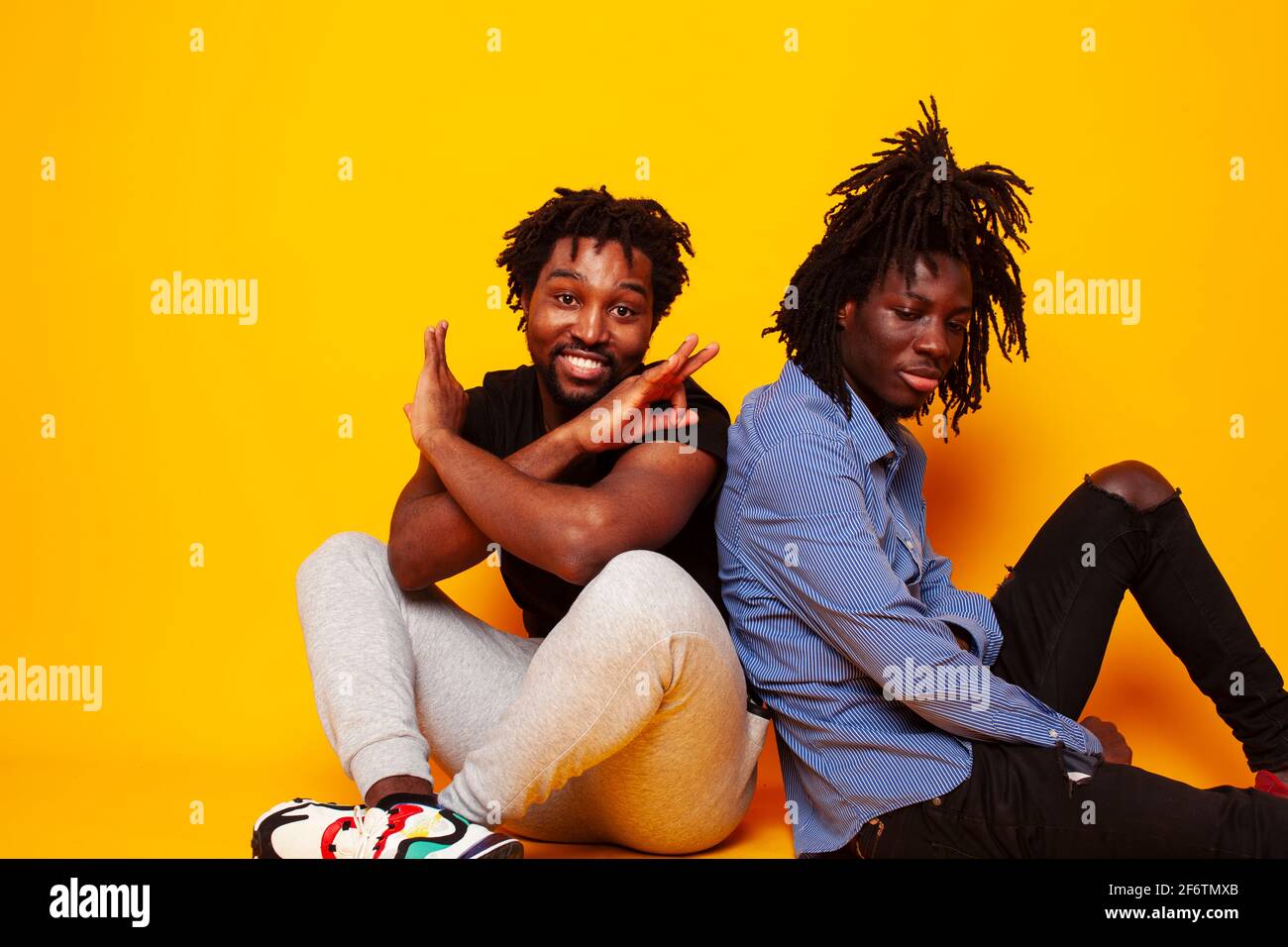two african american guys posing cheerful together on yellow background ...
