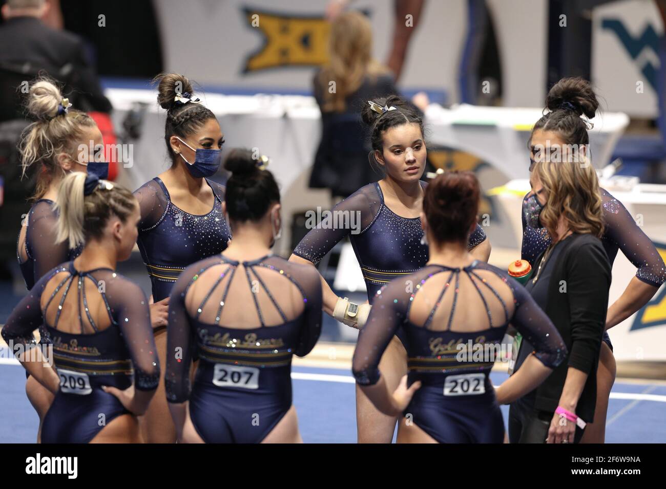 April 2, 2021: The Cal gymnastics team huddles on the floor apparatus ...