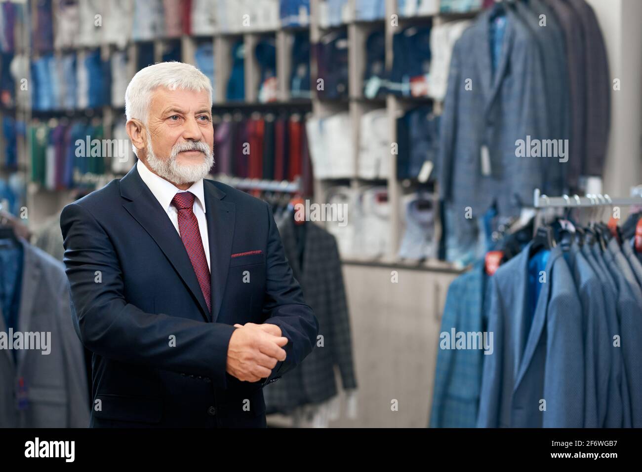 Portrait of older elegant client in black costume with gray beard ...