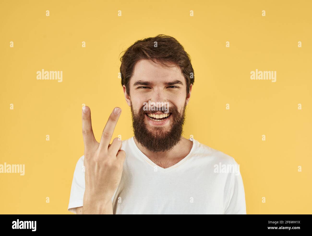 Man shows positive hand gesture emotions fun yellow background Stock Photo - Alamy
