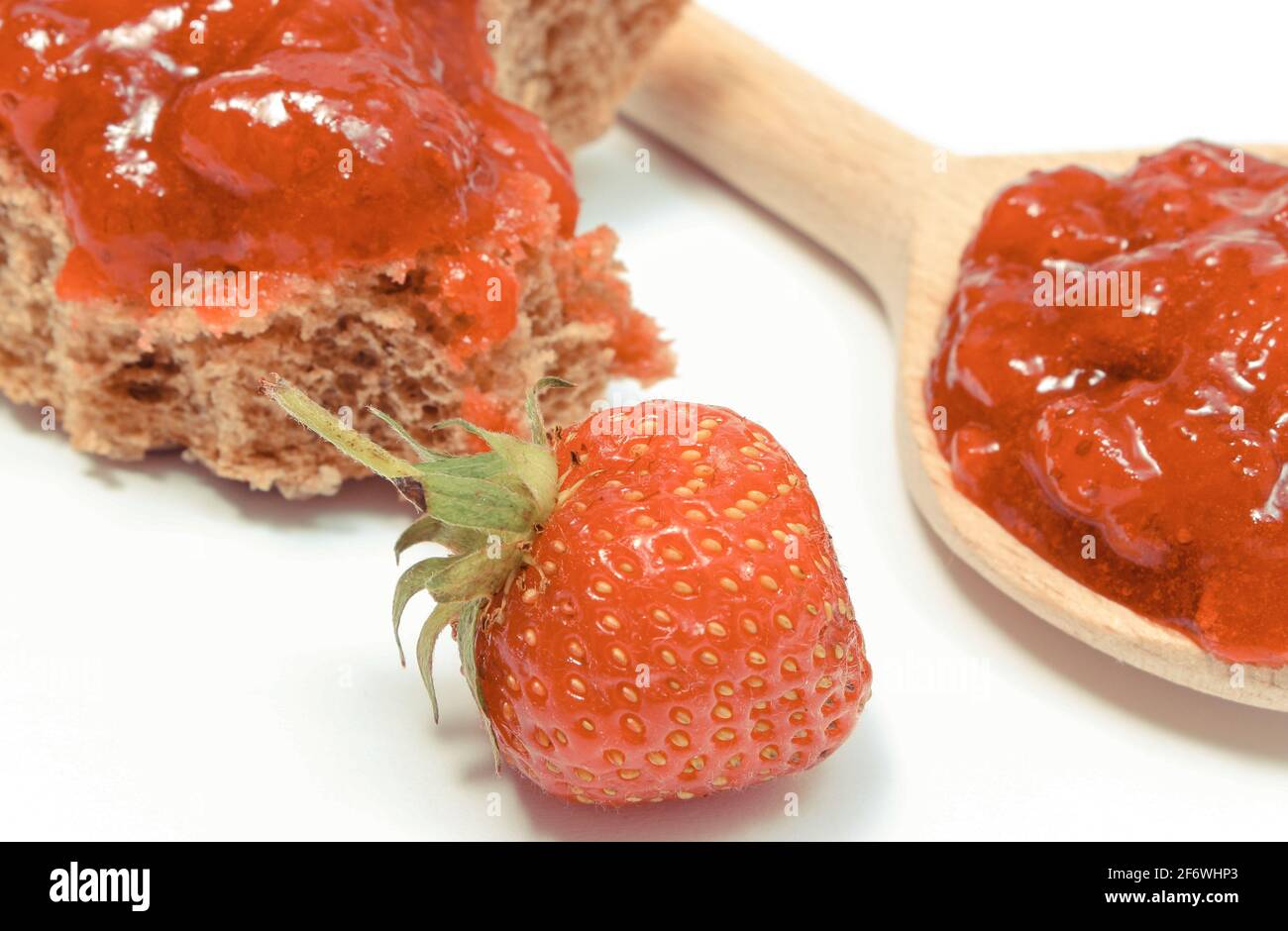 Fresh fruits, homemade strawberry jam on wooden spoon and portion of ...