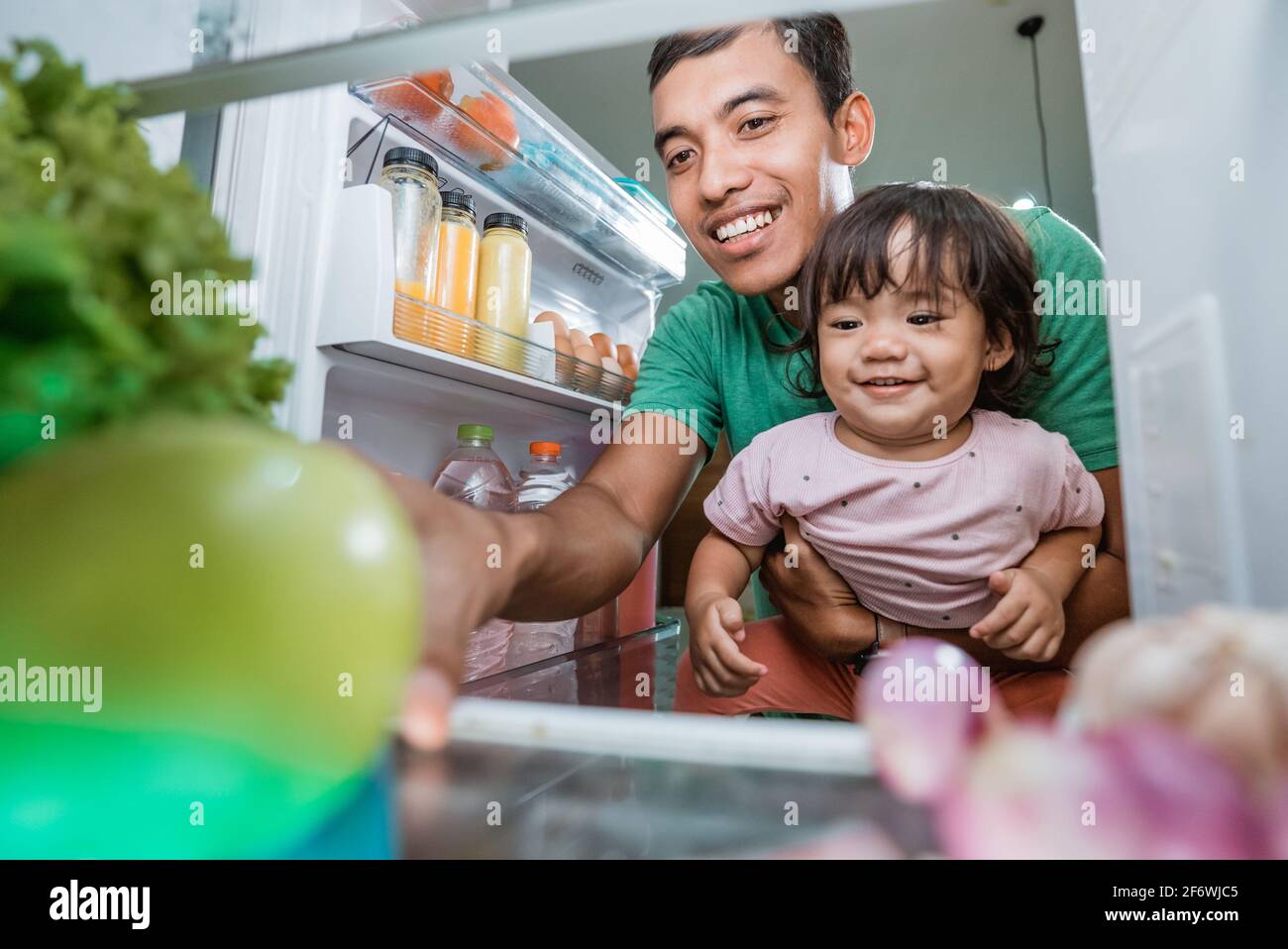 little girl and her dad looking inside the fridge Stock Photo - Alamy