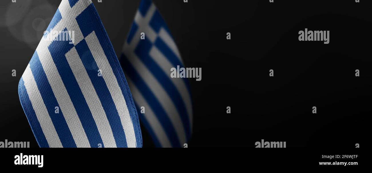 Small national flags of the Greece on a dark background Stock Photo - Alamy