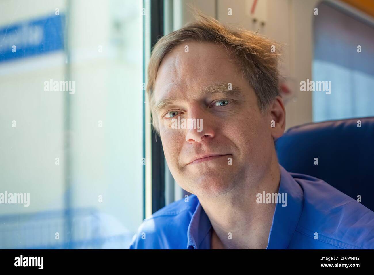 Handsome man smiling on blue hi-res stock photography and images - Alamy