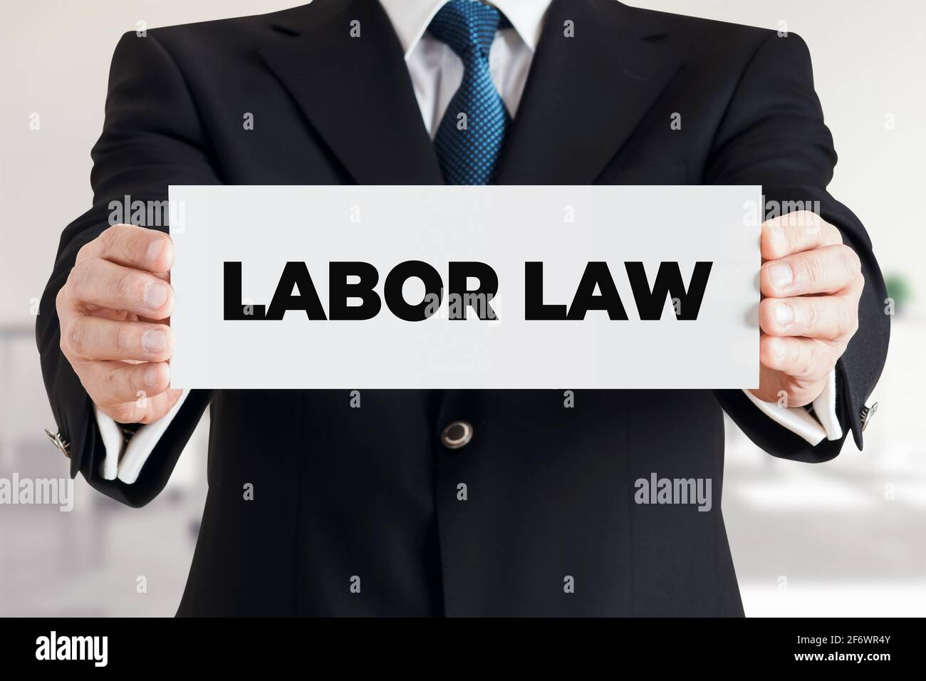 Businessman shows a banner with the message labor law Stock Photo - Alamy
