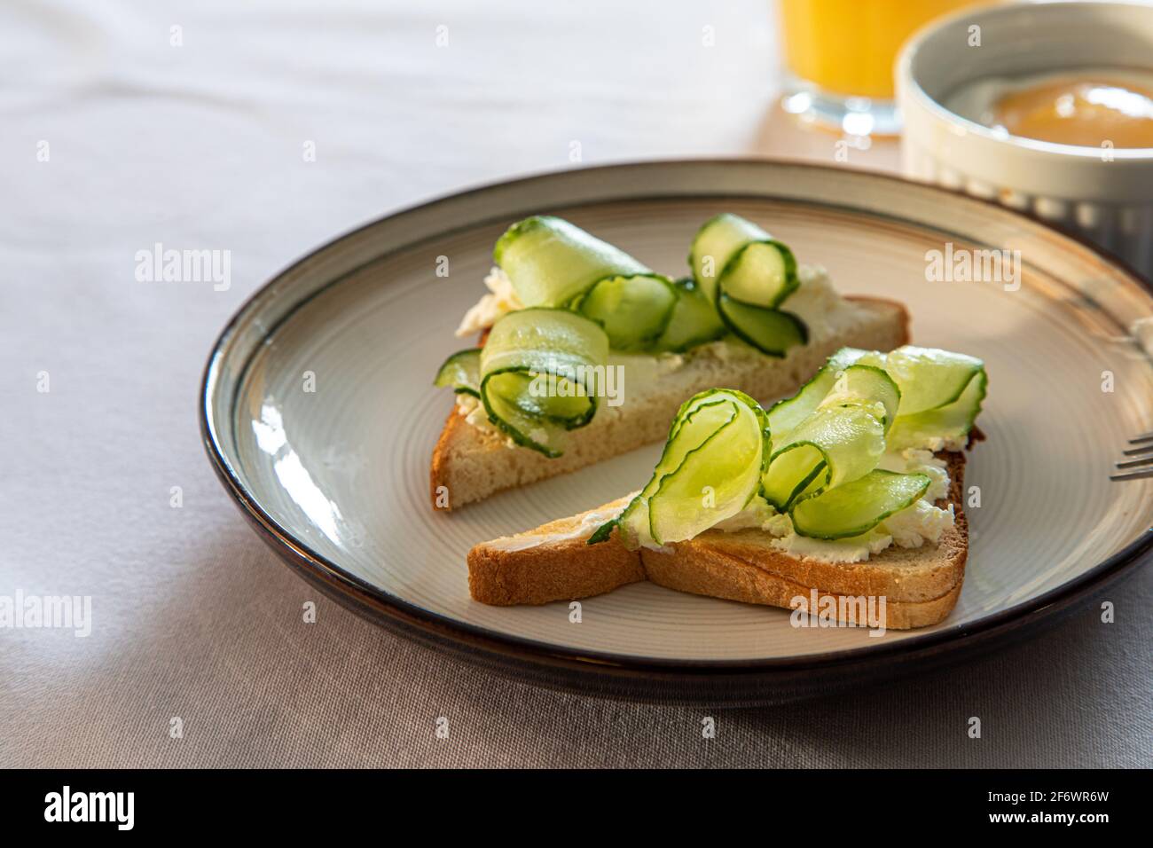 Cucumber and cream cheese toast on a plate. Healthy vegetarian diet ...