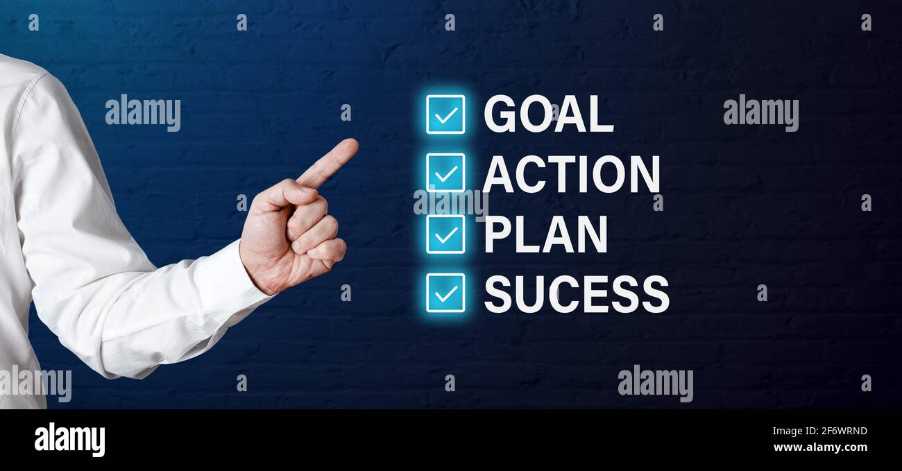 Businessman hand points to the words goal, plan, action, and success ...
