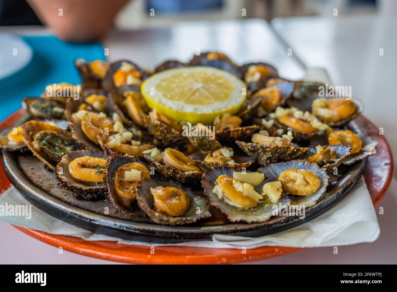 tasty seafood - grilled limpets served with lemon. Lapas grelhadas ...